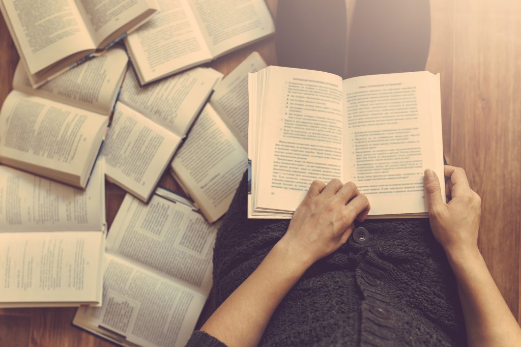 Woman reading a few books on the floor — The James G. Martin Center for ...